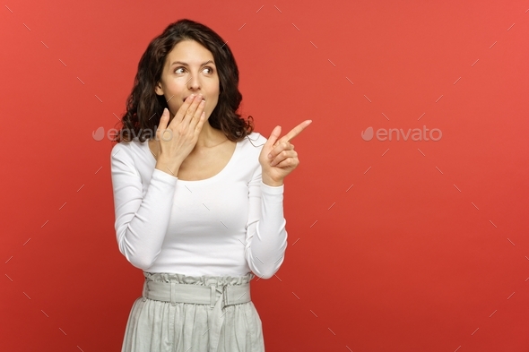 Portrait of surprised young woman shocked point finger to empty space ...