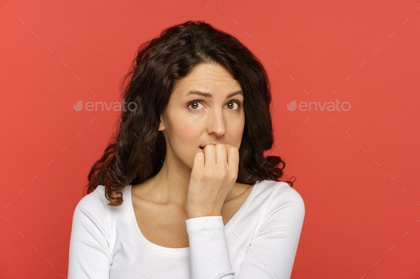 Worried young woman scared in stress biting nails get in trouble ...