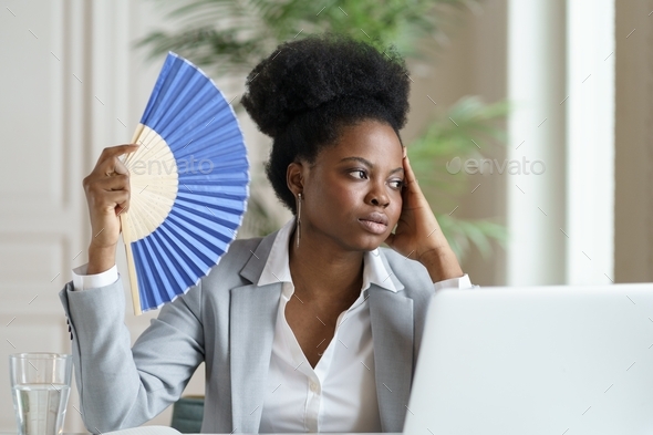 Tired businesswoman waving paper fan exhausted of heat overheated at ...