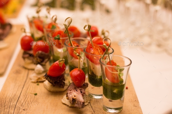 Canape with cherry tomatoes in sauce and glasses. Food and drink ...