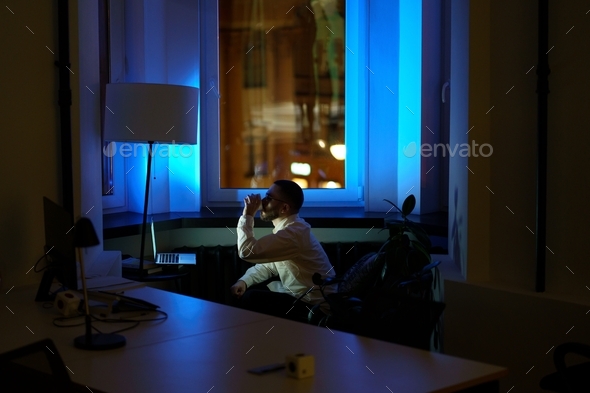 Tired programmer stay at work overtime at night before project deadline ...