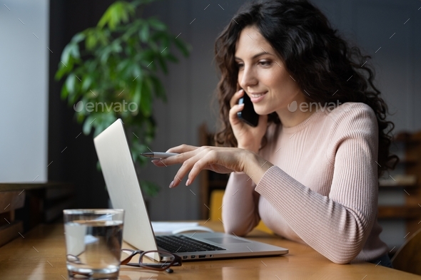 Smiling girl consultant talk to customer on phone call, read email ...