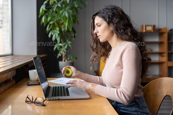Focused businesswoman work on laptop hold expander in hand massaging ...