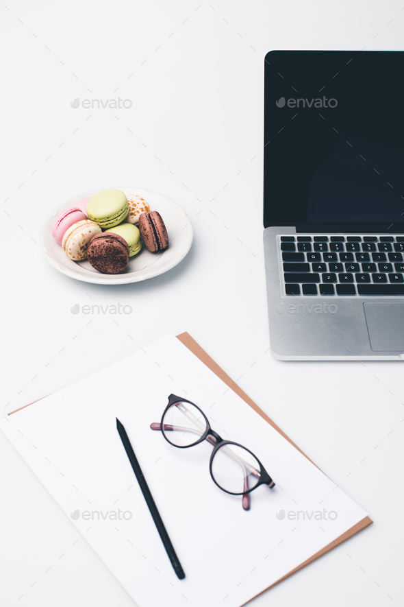 modern workplace with opened laptop and plate of macaroons Stock Photo ...