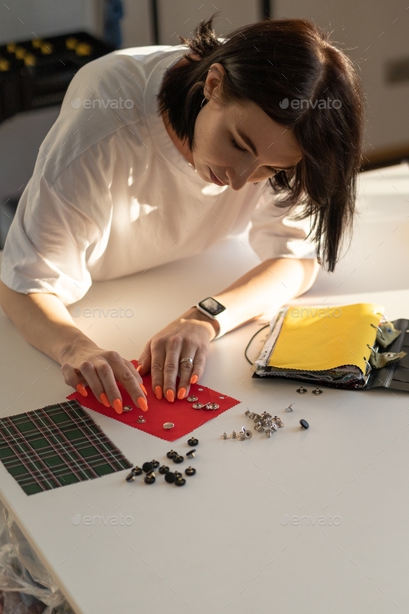 Young designer tailor woman choose swatches of fabric in studio. Girl ...