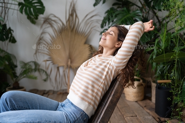 Dreamy relaxed young brunette girl enjoying peace and relieving stress ...