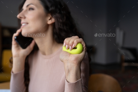 Young smiling female employee squeezing grip ring, practicing hand and ...