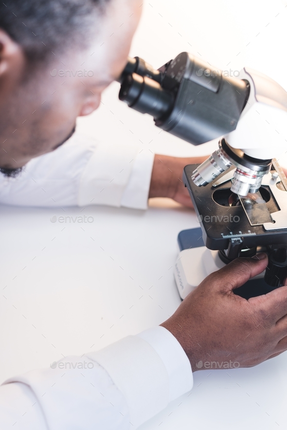 african american scientist in the STEM field using compound microscope ...