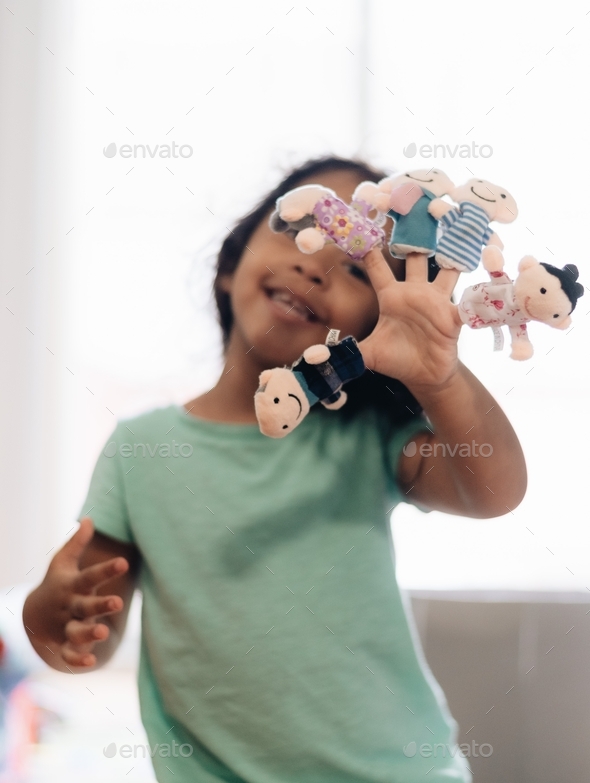 Diverse girl at home playing with ginger puppets Stock Photo by rohaneh