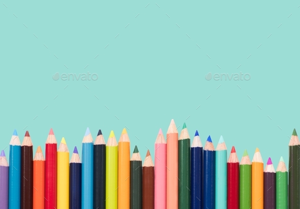 Colored pencils of various colors lined up on a teal background Stock ...