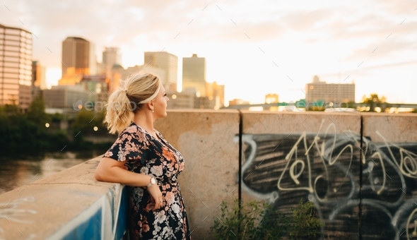 Young millennial girl in city posing for portrait at sunset Stock Photo ...