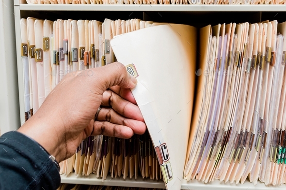Medical records, charts, African American man sorting through patient ...