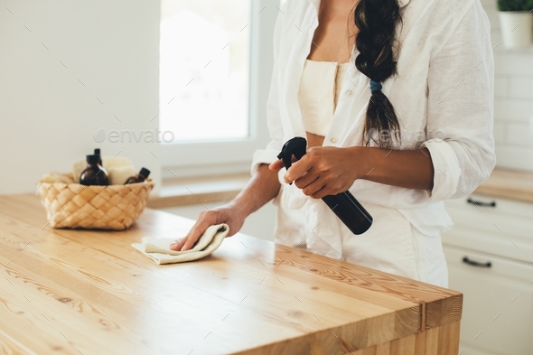 Woman cleaning table in kitchen using natural wooden eco friendly rag ...