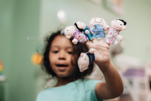 Diverse girl at home playing with ginger puppets Stock Photo by rohaneh