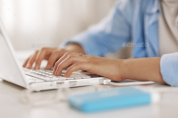 Close-up of female hands on the laptop keyboard. Side view, technology ...