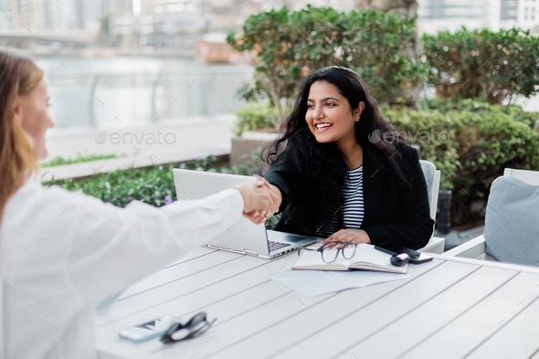 Two businesswomen make a deal during a meeting in a cafe. Business ...