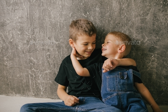 Two boys brothers sitting on floor, hugging and having fun. Stock Photo ...