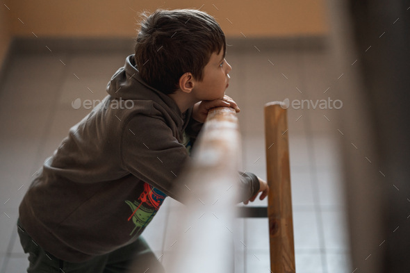 A brooding teenage boy in the entrance on the stairs Stock Photo by ...