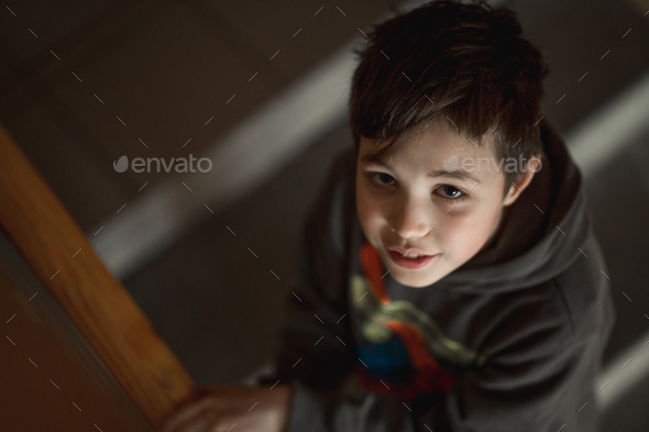 A brooding teenage boy in the entrance on the stairs Stock Photo by ...