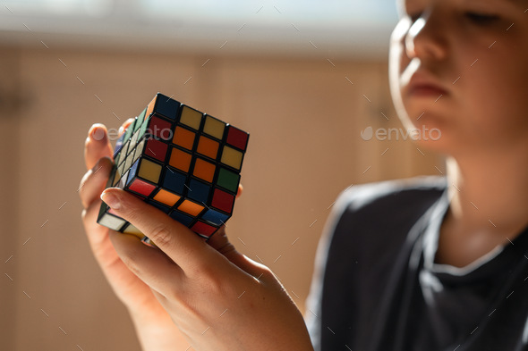 The teenager is trying to collect a Rubik's Cube. The boy solves the ...