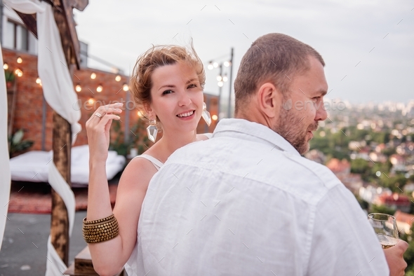 Fashion stylish woman looks over the shoulder of young man, hugs ...