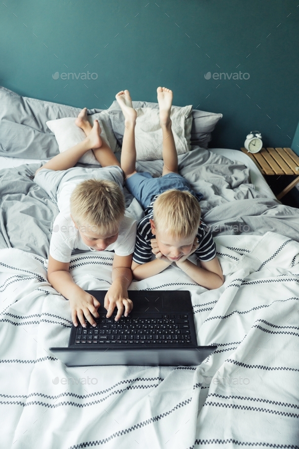 The boys playing the computer game laugh and have fun. Children ...