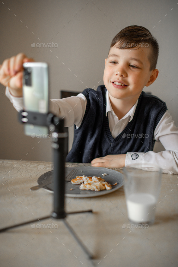 schoolboy records a video clip in tik tok Stock Photo by nastuffa ...