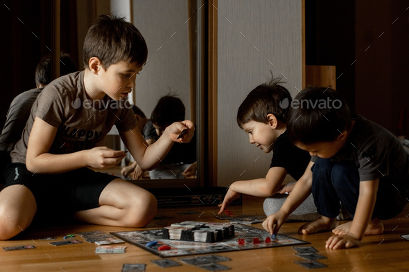Boys, brothers play a board game. Children play monopoly Stock Photo by ...