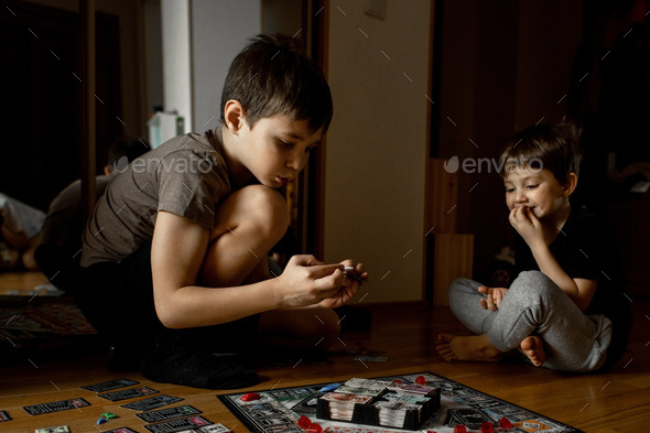 Boys, brothers play a board game. Children play monopoly Stock Photo by ...