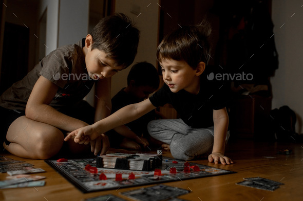 Boys, brothers play a board game. Children play monopoly Stock Photo by ...