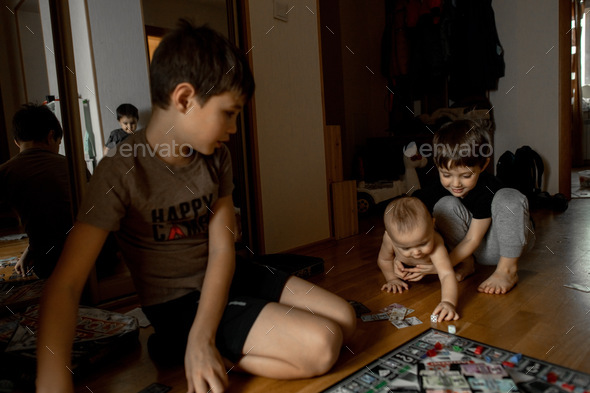 Boys, brothers play a board game. Children play monopoly Stock Photo by ...