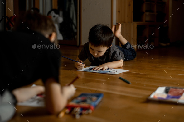 Two brothers draw a drawing with colored pencils Stock Photo by nastuffa