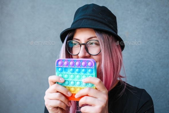 Young Girl Holding pink Pop It Fidget Toy in hands. Teen Playing Stock ...