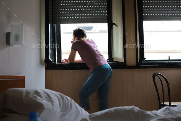 view from the back, a woman looks out the window from the house. people ...