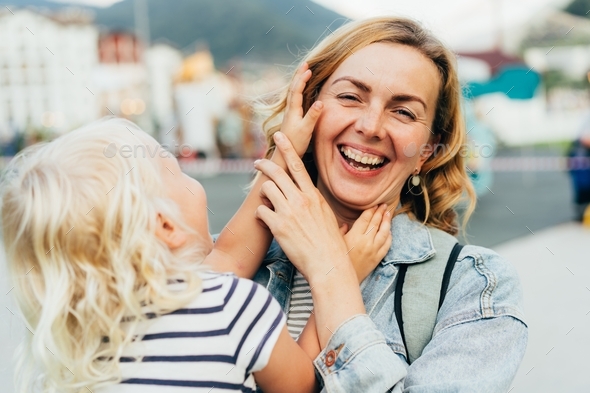 Happy mom and little daughter. Mom holds the child in a gentle embrace ...