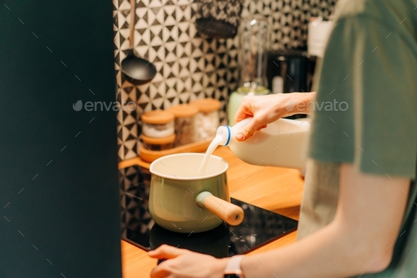 Close-up woman cooking breakfast on the stove Stock Photo by titovailona