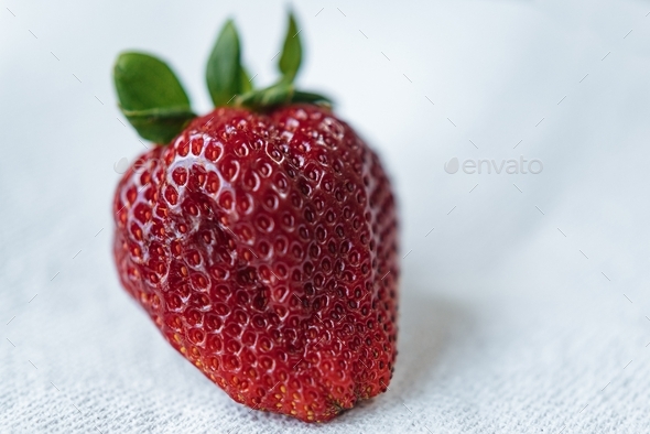 Close-up macro photo of the dark red sweet strawberry on a white ...