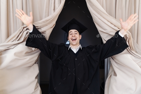 Portrait fresh smiling graduate with come out of curtains with raising ...