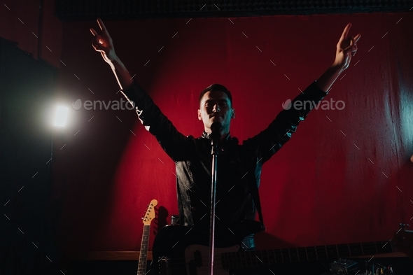 Guy performing in a club holding hands up. Music, passion, hobby ...