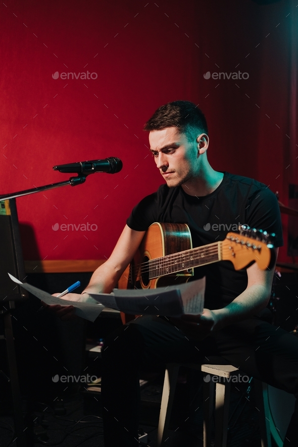 Man writing song in an authentic studio with an acoustic guitar ...