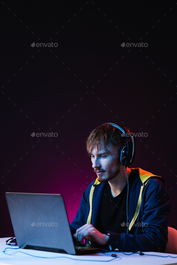 Hacker it genius using laptop writing code wearing hood on head. Cyber ...