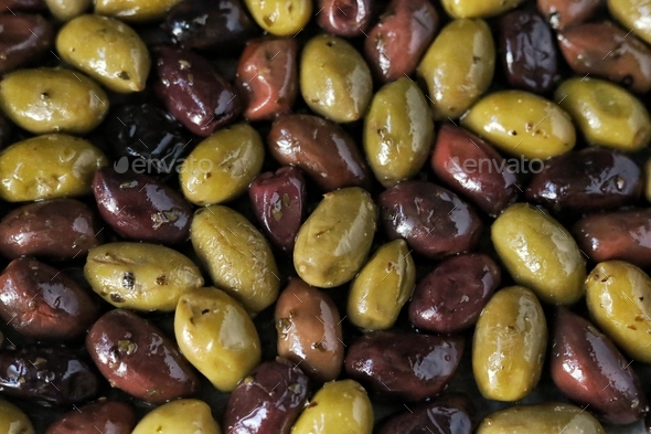 Well-lit textured background of assorted olives of different colors ...