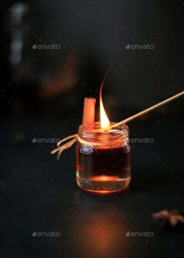 A two-layer alcoholic cocktail shot set on fire with a match, with a ...