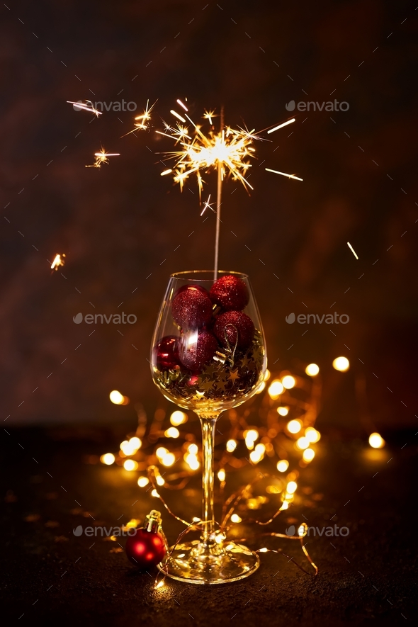 Burning bengal firework in wine glass with red Christmas balls Stock ...
