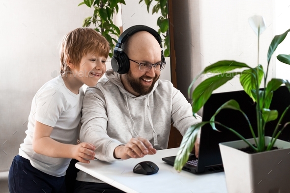 Dad and son laughing having fun and playing a video game on the ...