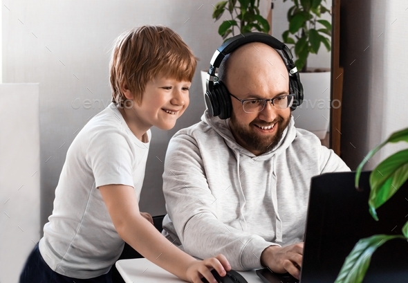 Dad and son laughing having fun and playing a video game on the ...