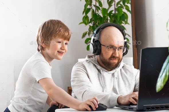 Dad and son laughing having fun and playing a video game on the ...