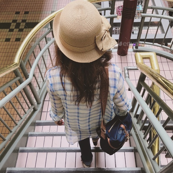 Woman descending a staircase at a shopping center Stock Photo by debbalba