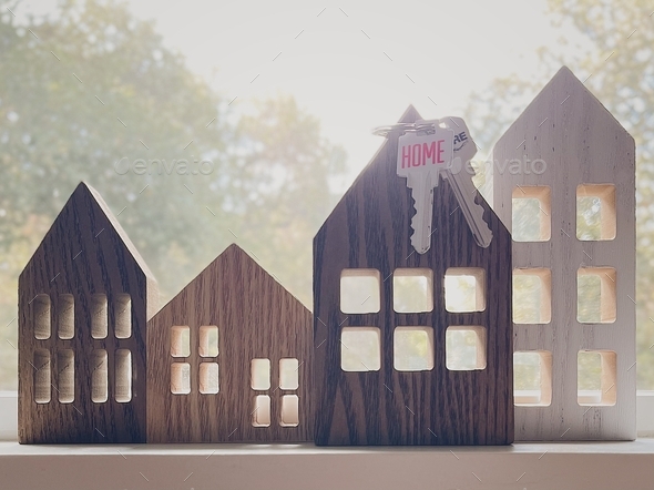 Wooden homes with cutout windows with keys hanging and a bokeh of trees ...