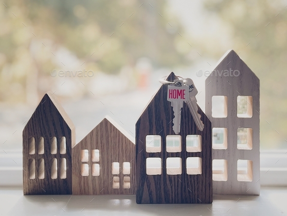 Wooden homes with cutout windows with keys hanging and a bokeh of trees ...